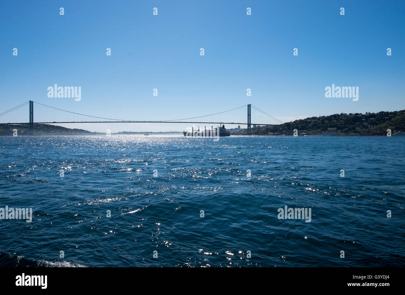 Bosphorus waterway, Istanbul, large cargo ship passes under bridge ...