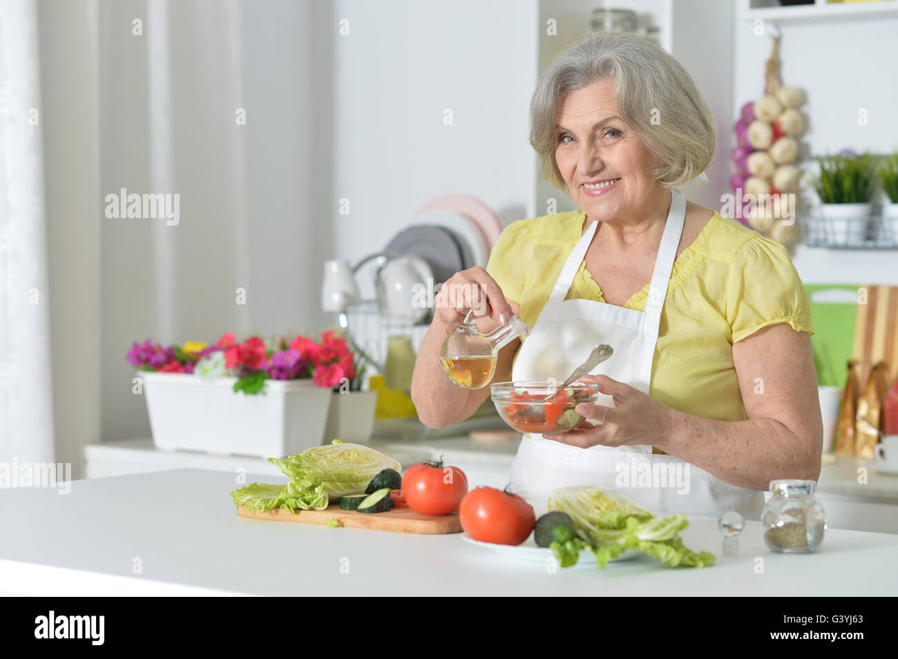Senior woman cooking in kitchen Stock Photo - Alamy