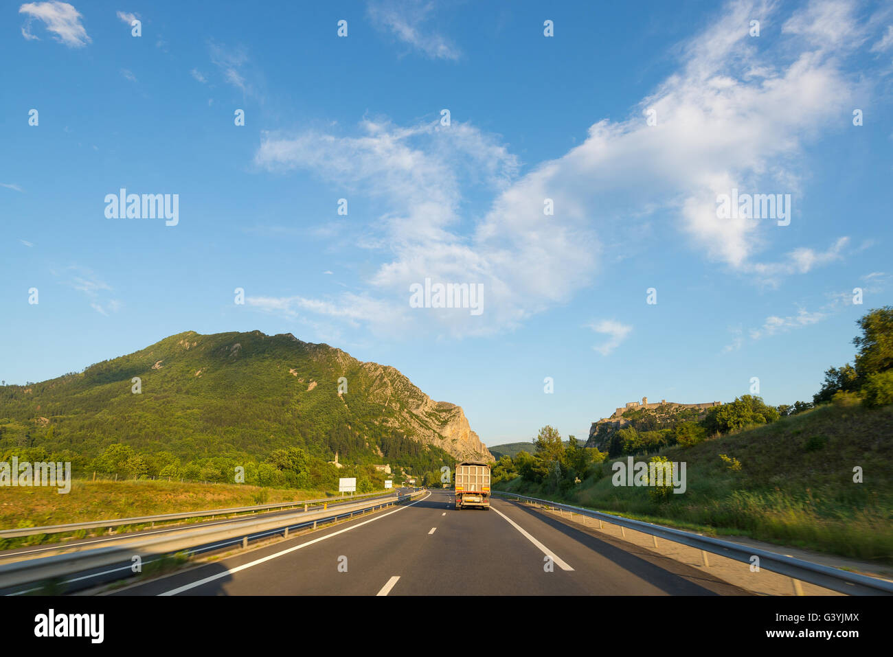 Paved two lane road crossing mountains and forest in scenic alpine ...