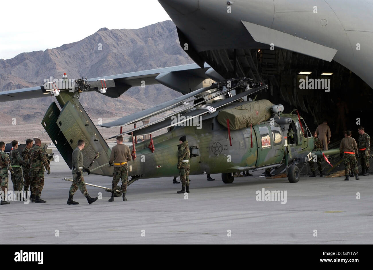 Airmen load an HH-60 Pave Hawk helicopter aboard a C-17 Globemaster III ...