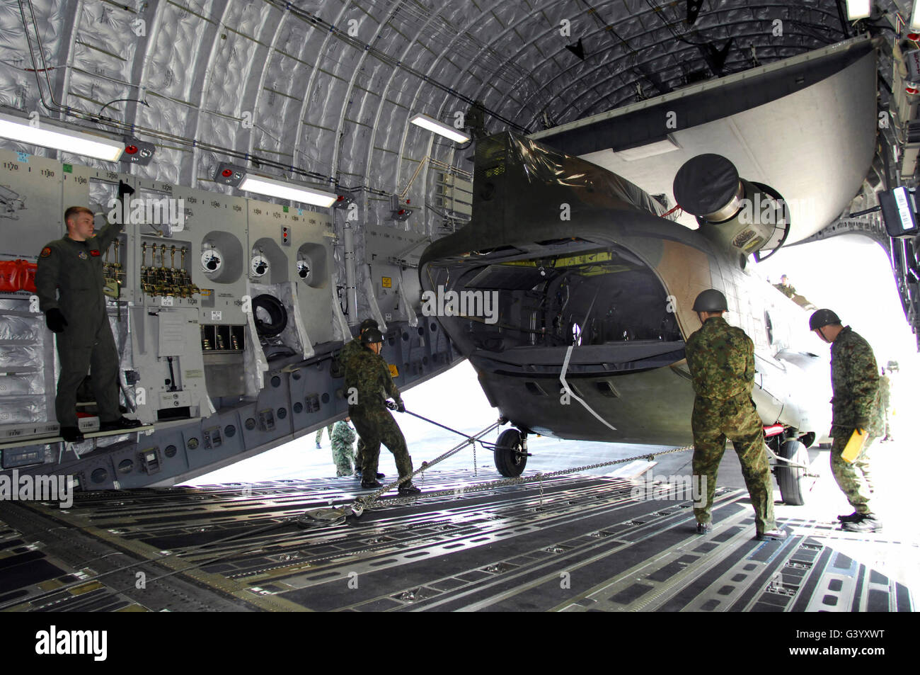 A CH-47J Chinook is loaded onto a C-17 Globemaster III cargo plane ...