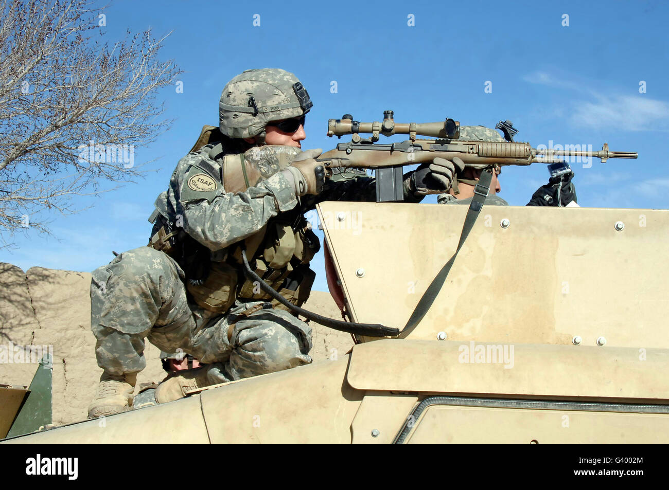 U.S. Army soldier looking through the scope of his rifle onto a mortar ...