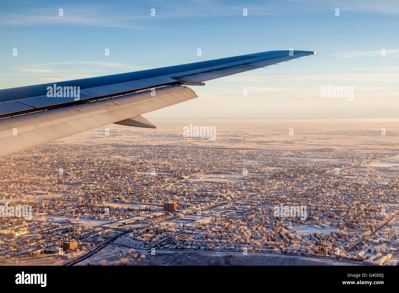 Airplane window view showing wing of the plane flying over a snow ...