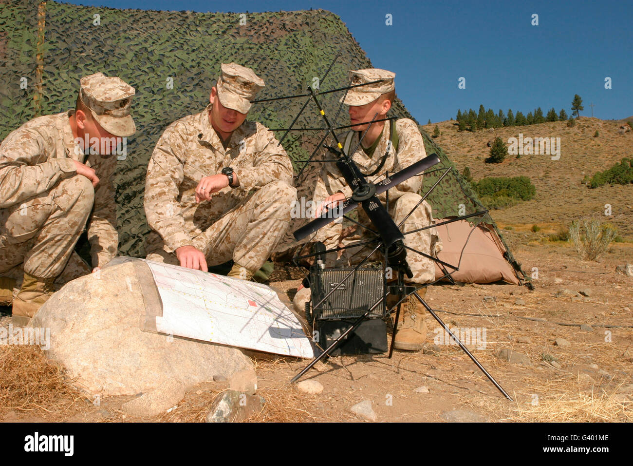 Soldiers analyze the finer points of a terrain map at a radio ...