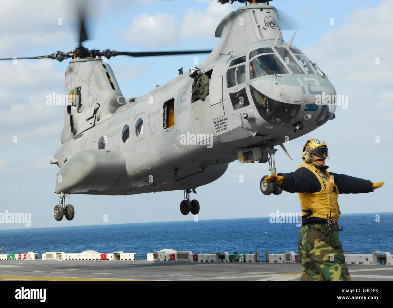 A CH-46E Sea Knight helicopter takes off from the flight deck of USS ...