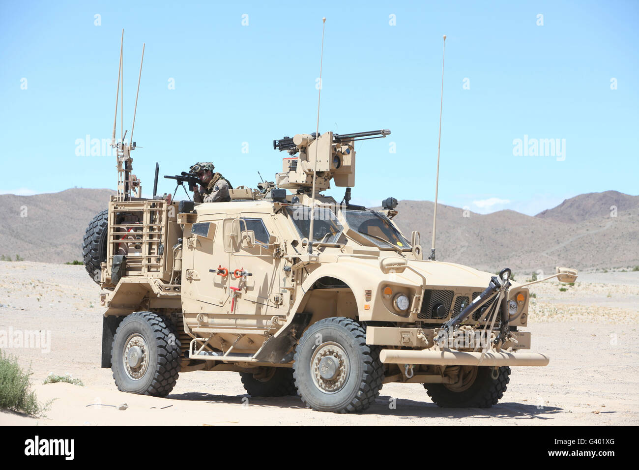 A Marine sniper provides security from the back of an Oshkosh M-ATV ...