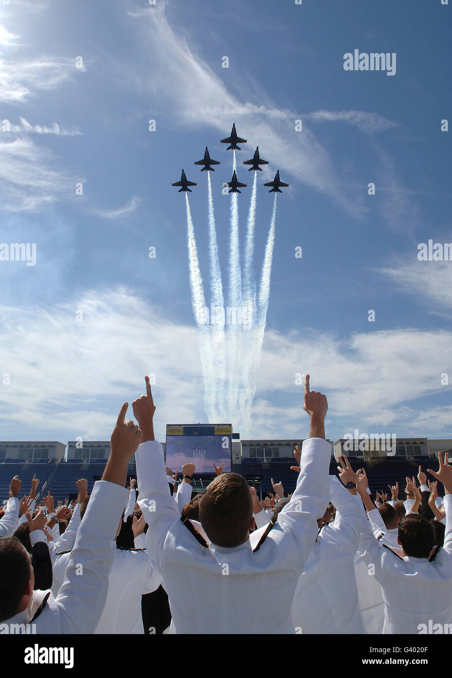 Members of the U.S. Naval Academy cheer as the Blue Angels perfom ...