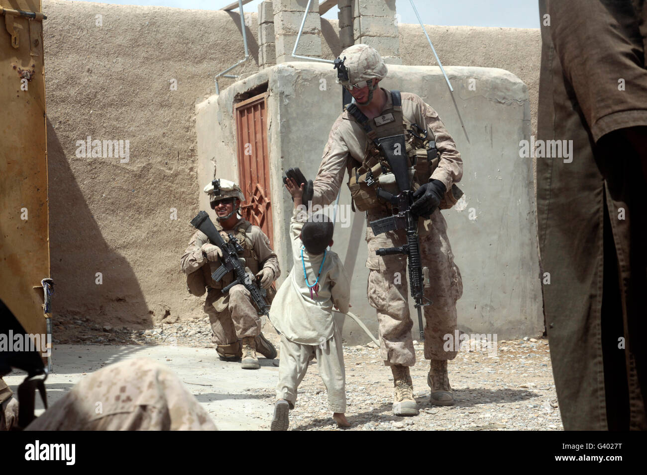 U.S. Marine gives an Afghan child a high-five while on a patrol in ...