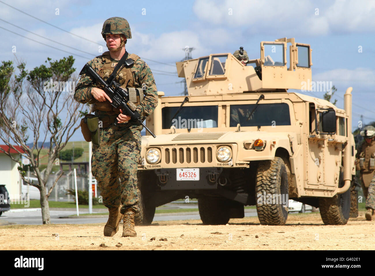 A U.S. Marine guides a Humvee through an entry control point in Japan ...