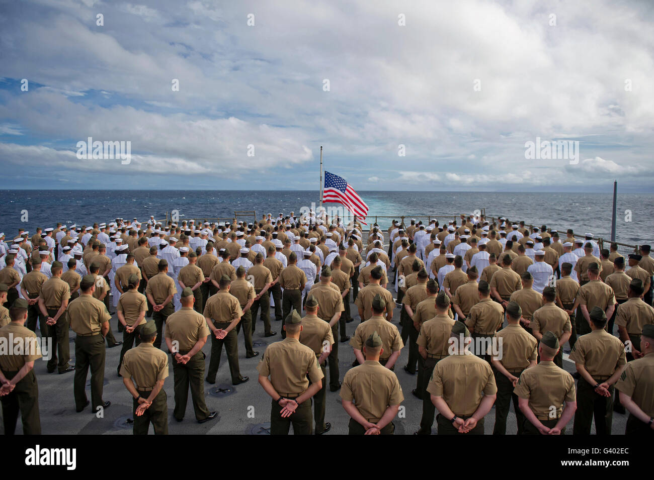 Marines and sailors stand in formation during a ceremony on USS Pearl ...
