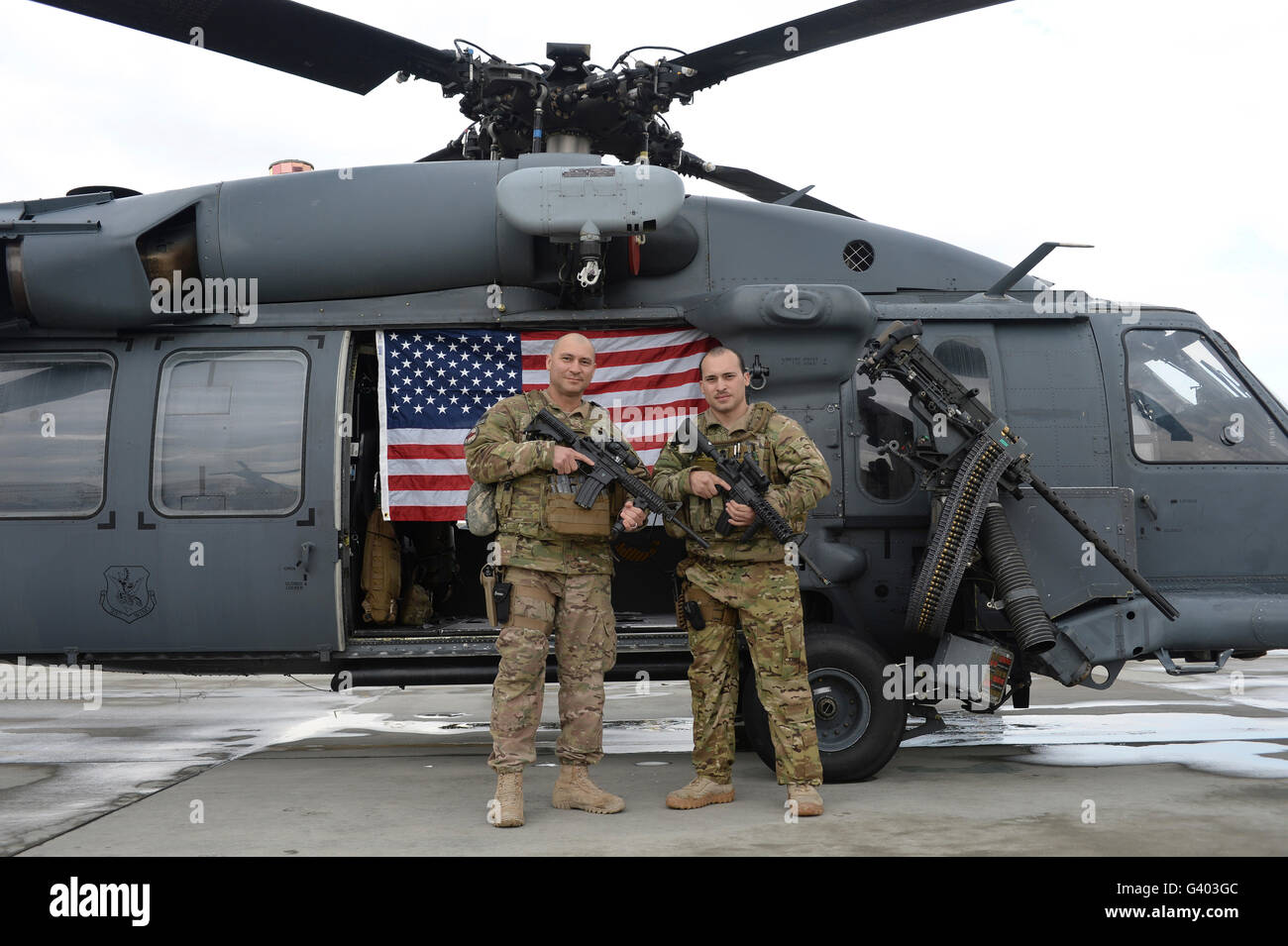 U.S. Air Force flight engineer and his father pose in front of an HH-60 ...