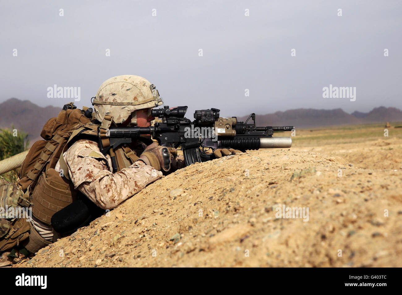 U.S. Marine provides security from the berm of a field in Afghanistan ...