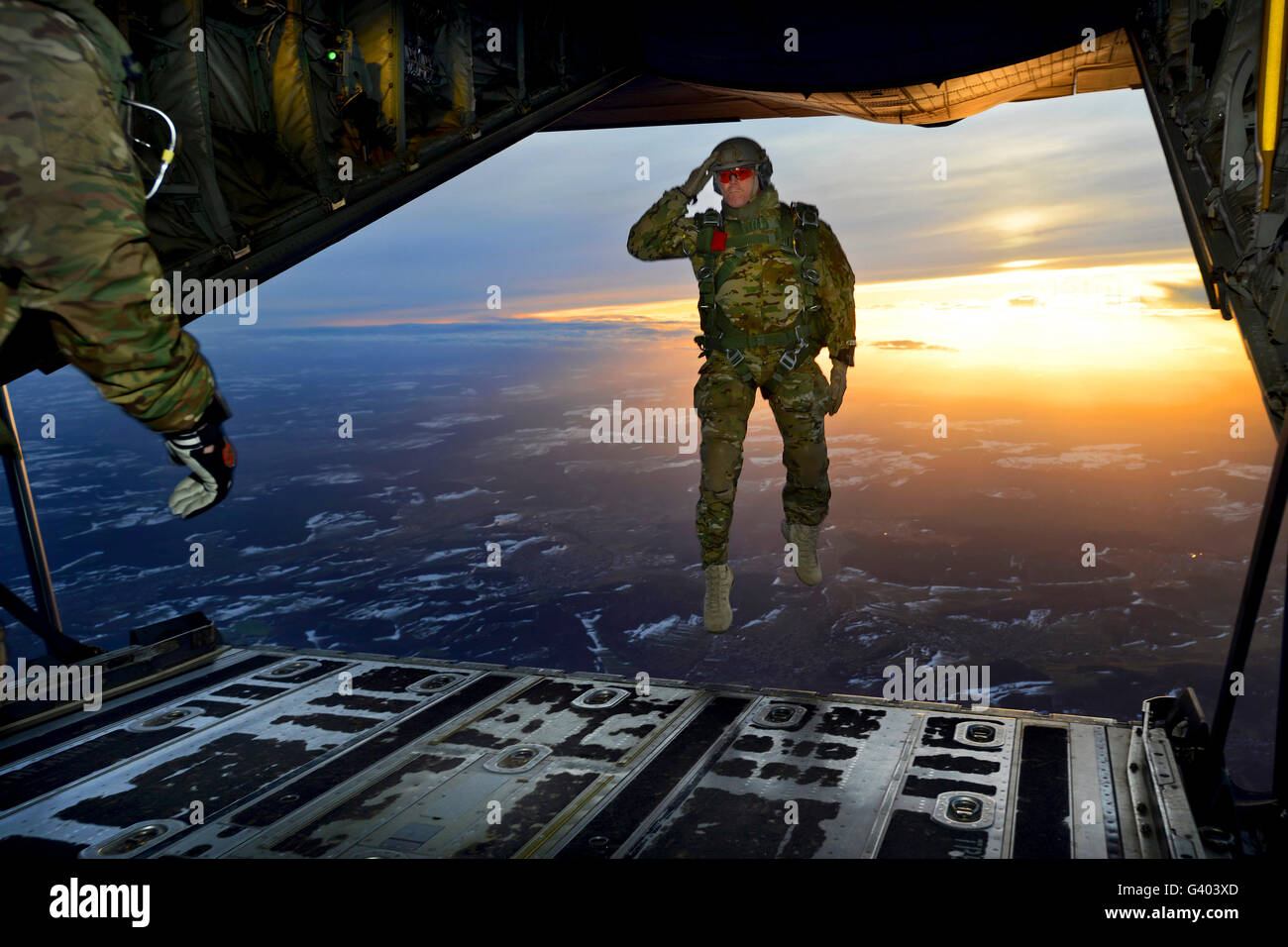 A U.S. Soldier salutes his fellow Soldiers while jumping out of a C-130 ...