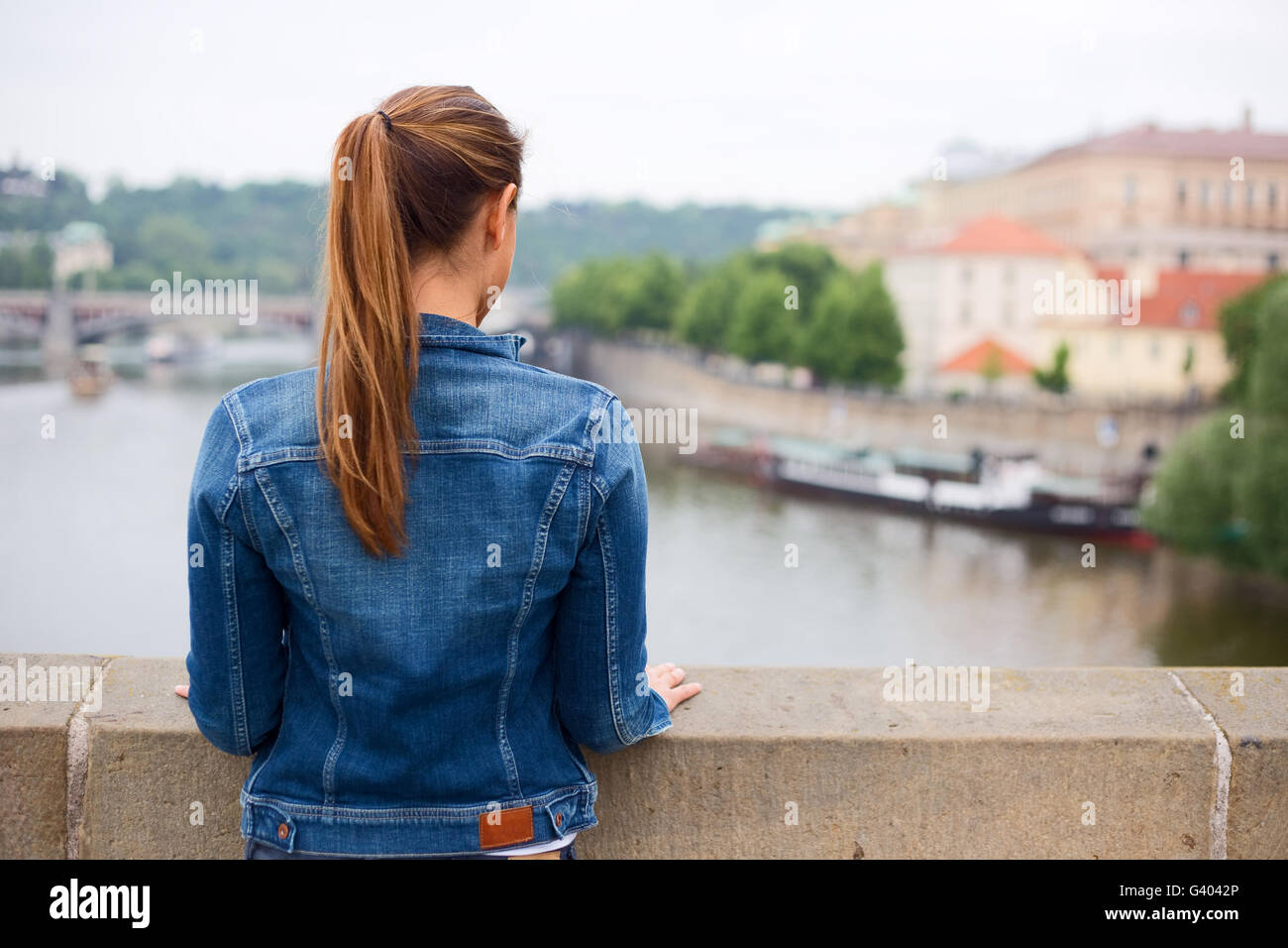 young woman looking out over the river enjoying the view Stock Photo ...