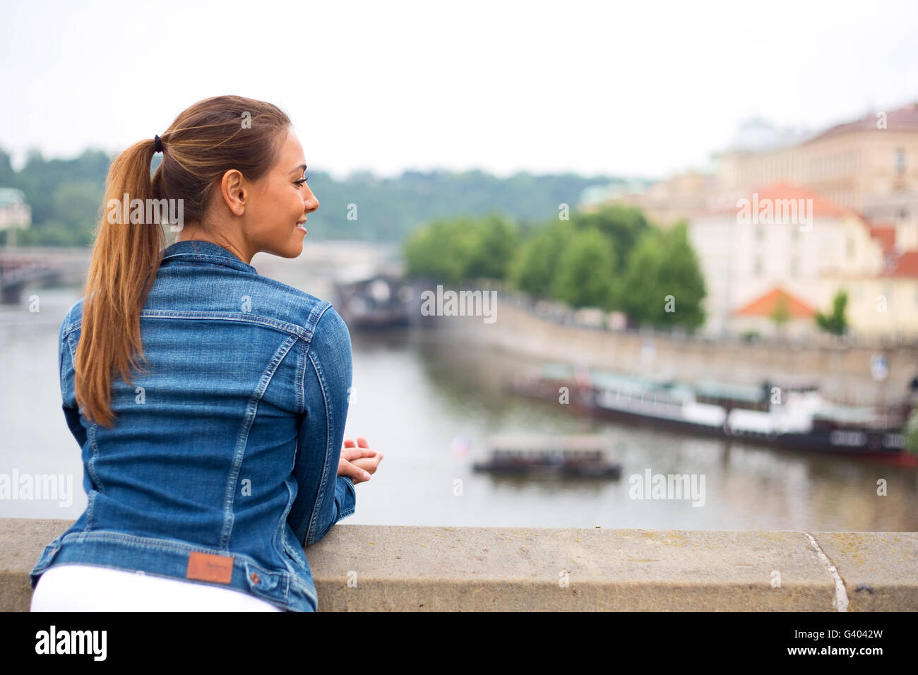 young woman enjoying the view from a bridge Stock Photo - Alamy