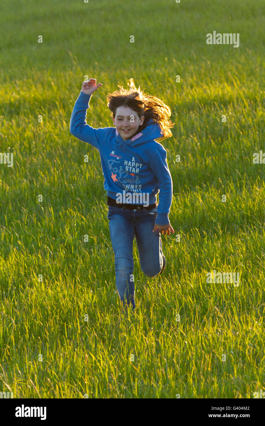Girl running in a field Stock Photo - Alamy