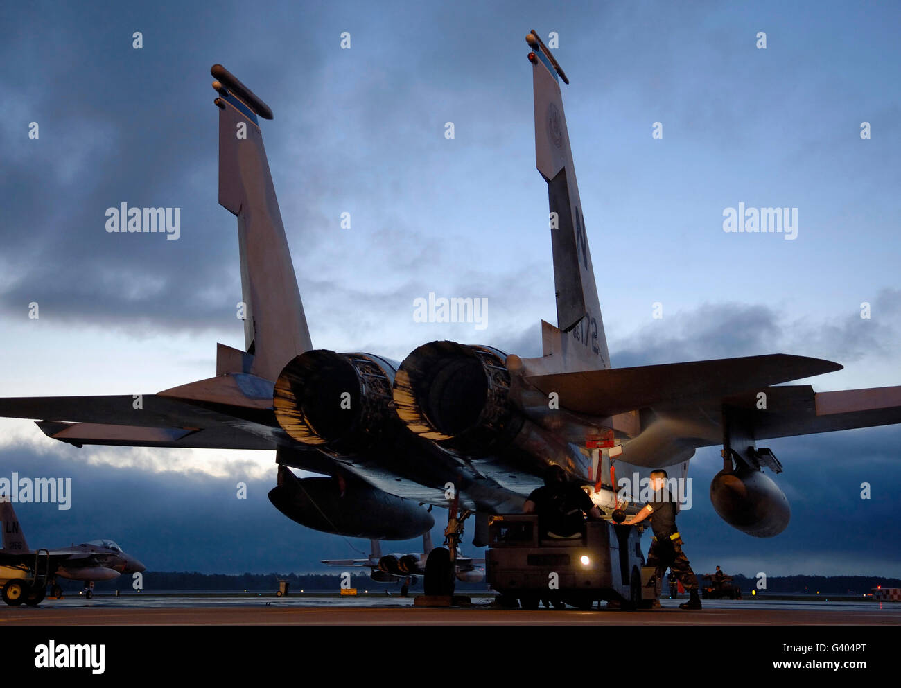 A weapons loading team attach an AIM-7M Sparrow missile on an F-15 ...