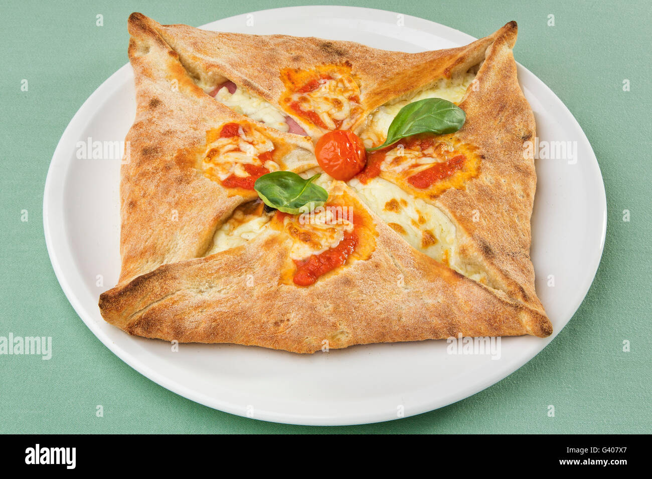 Italian Pizza calzone with mozzarella, ham and tomato Stock Photo - Alamy