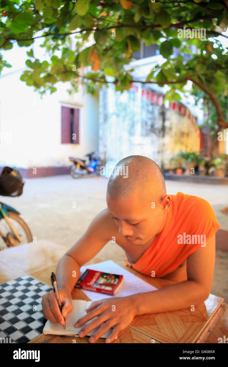 Laos Buddhist monk writing on a piece of paper Stock Photo - Alamy