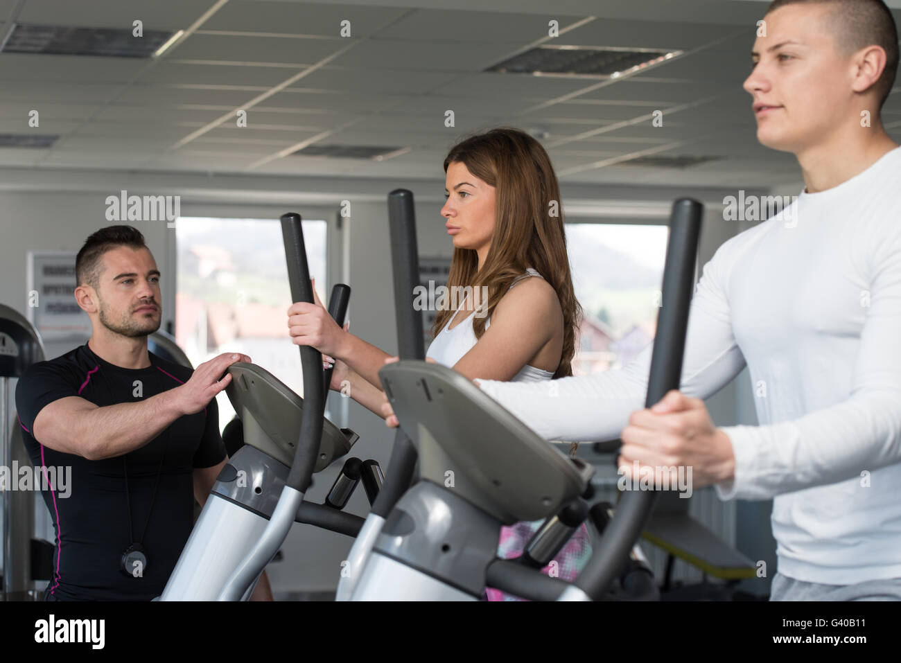 Group Of People Exercising On Elliptical Walker In Gym Or Fitness Club ...