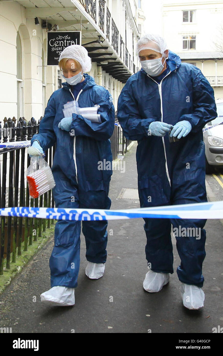 Police forensic officers enter a basement flat in Brighton, East Sussex ...