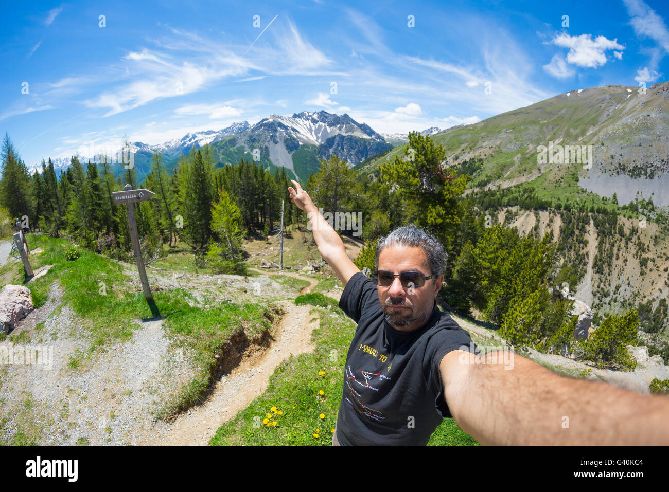 Selfie of adult hiker on top of trail crossing high altitude conifer ...