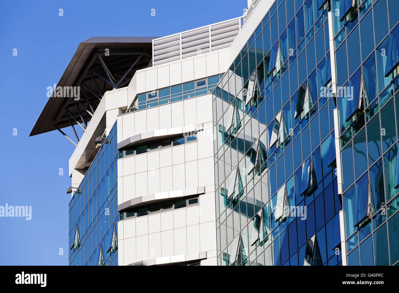 Reflections on modern building's blue and green glass facade Stock ...
