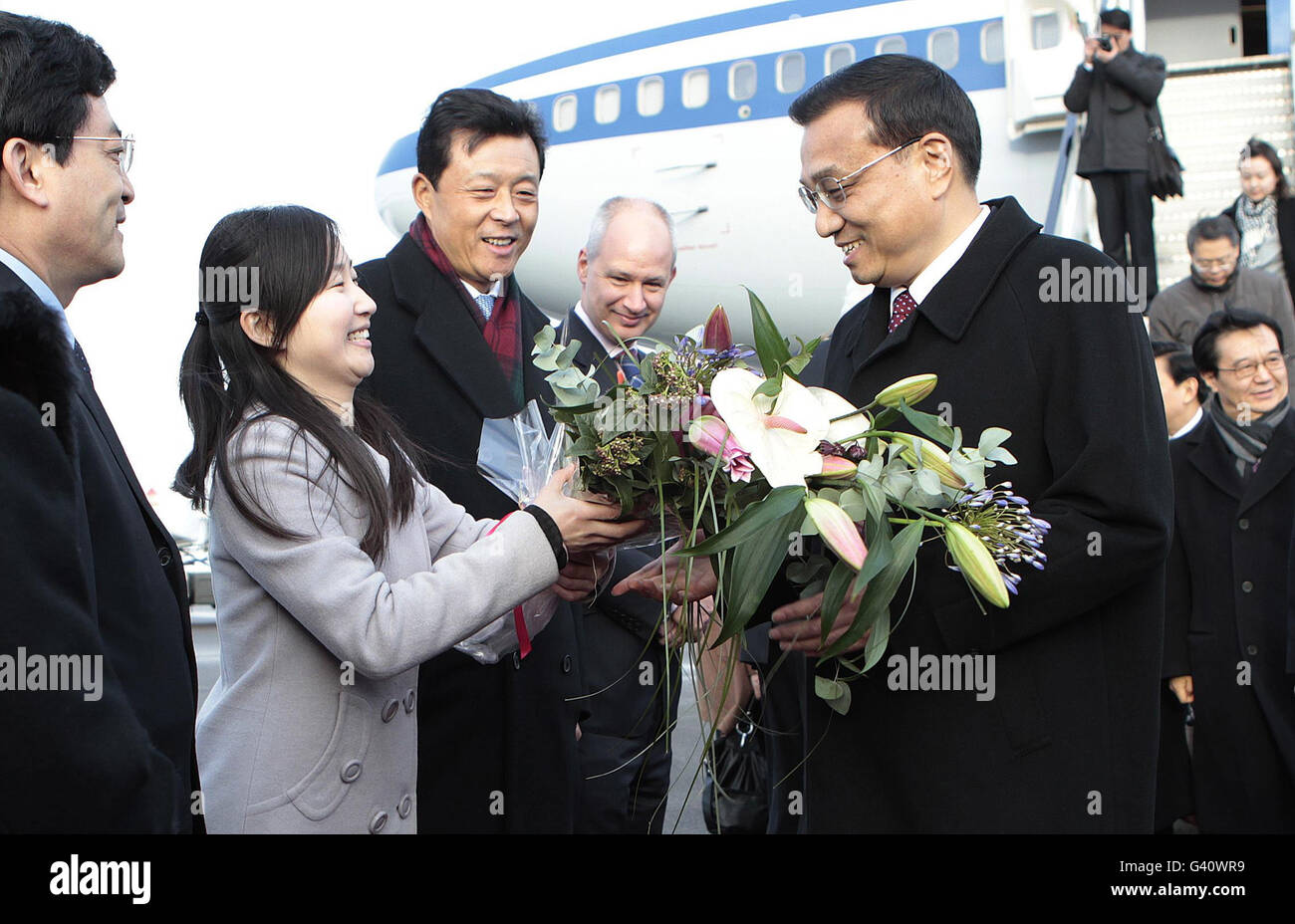 China's Vice Premier Li Keqiang accepts a bouquet of flowers as he ...