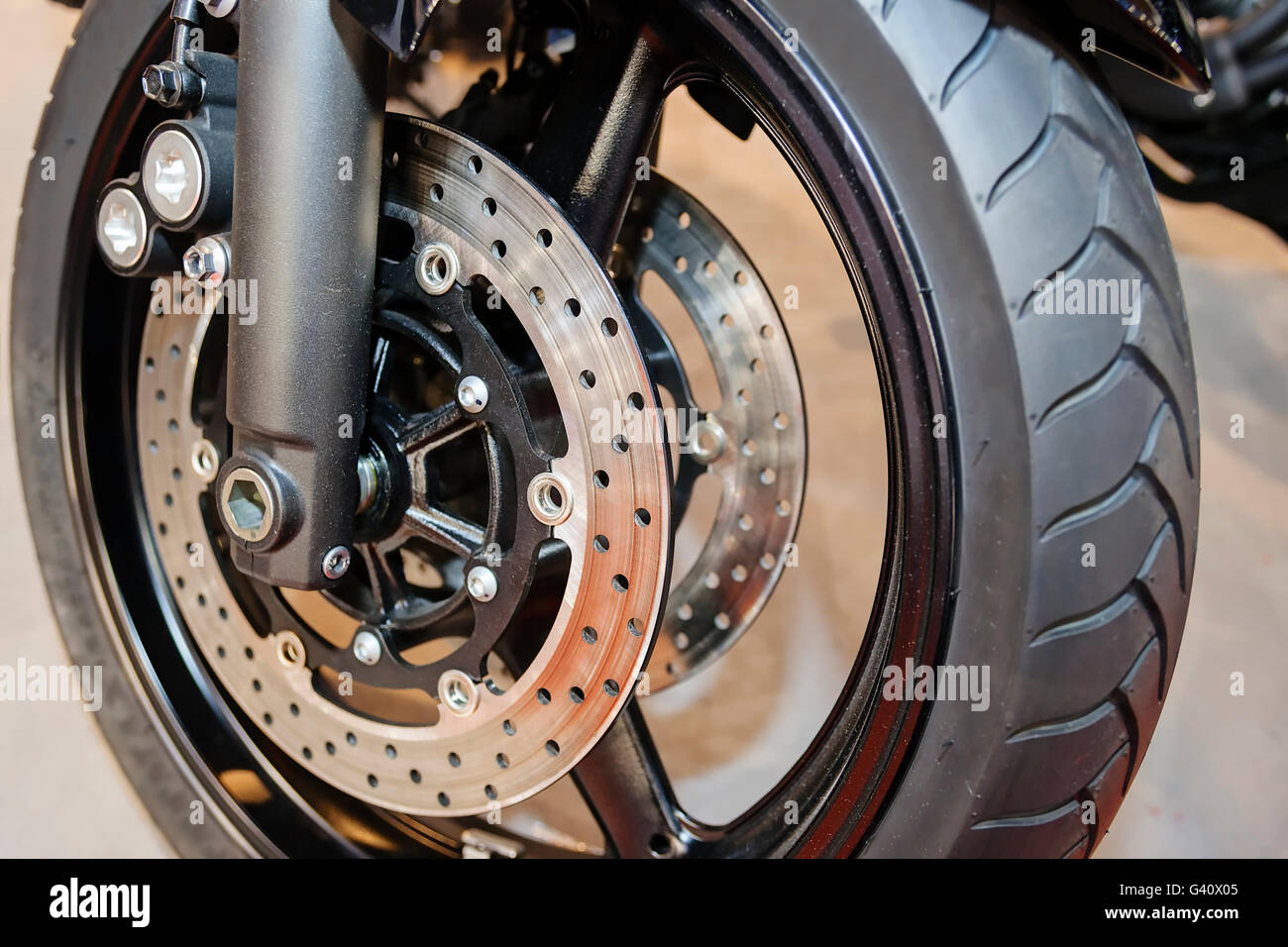 Closeup of quality steel motorcycle wheel with new tyre; note shallow ...
