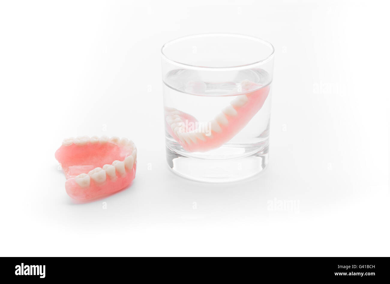 Full Denture in glass of water on white background Stock Photo - Alamy
