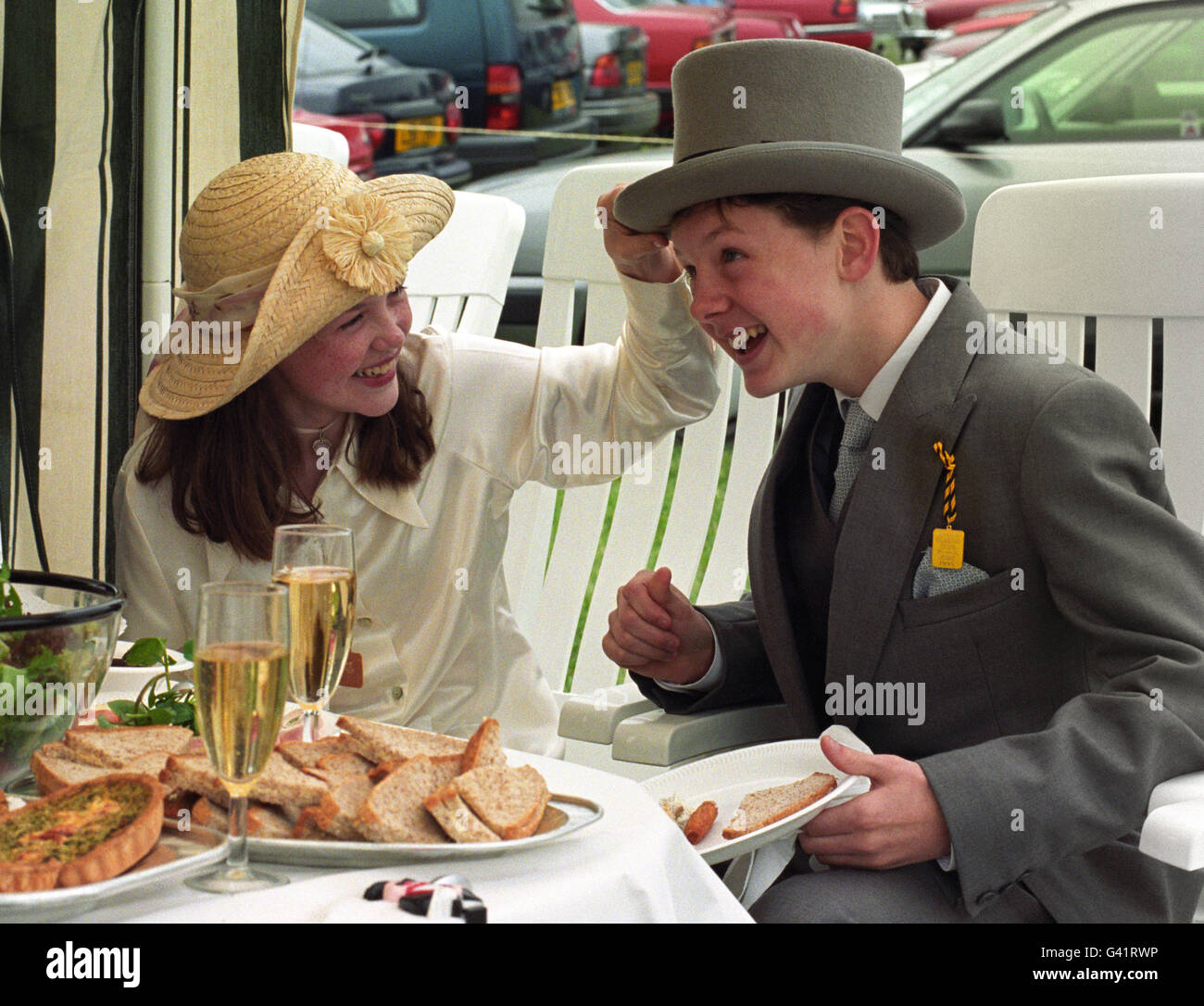 Young race-goer Daniel Barfield (14) has his hat straightened by his ...