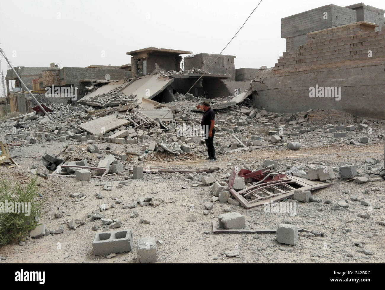 Fallujah, Iraq. 17th June, 2016. An Iraqi soldier stands near destroyed ...