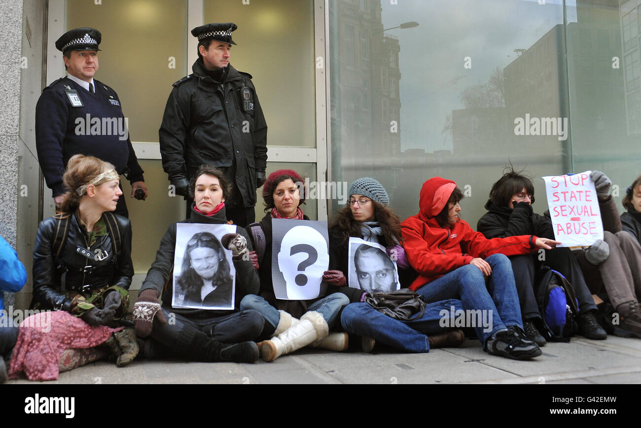 Policemen stand behind protesters as they blockade New Scotland Yard ...