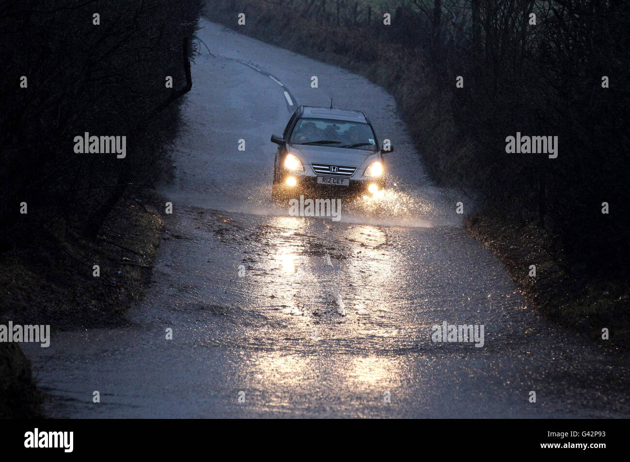 A car ploughs through a flooded road near Denny in Falkirk after heavy ...