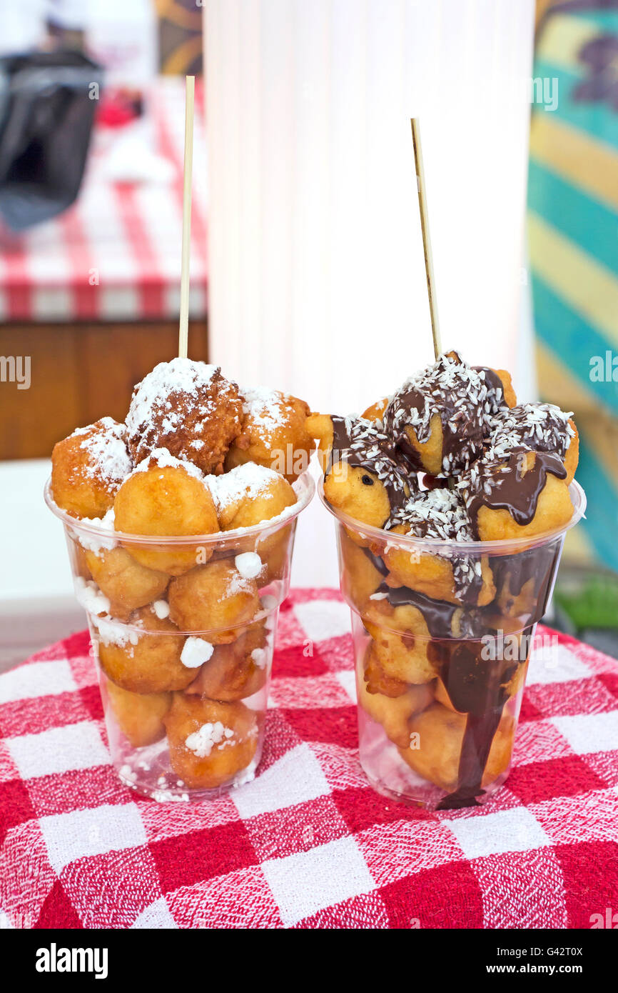 Homemade fritters with sugar and chocolate on a street stand ...