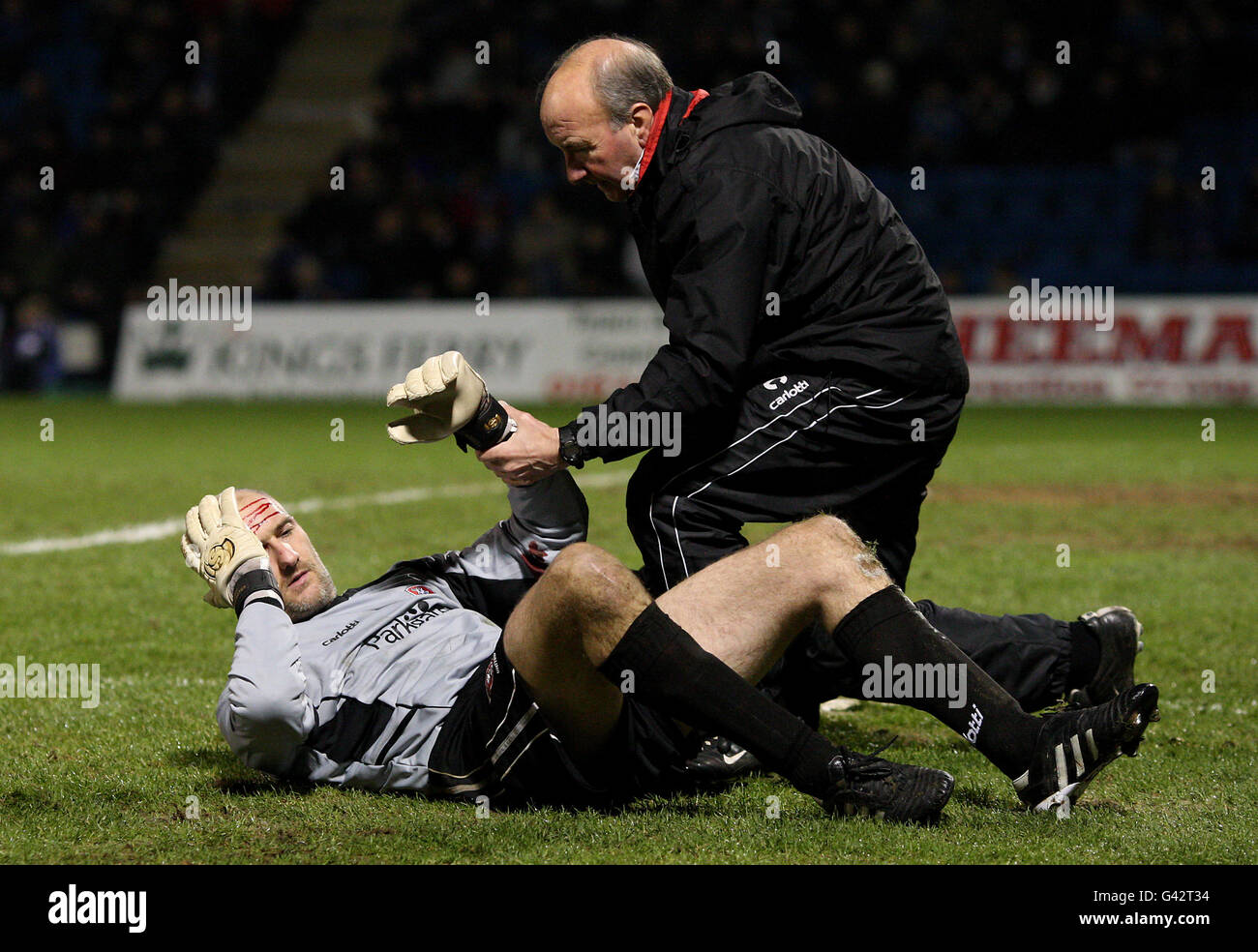 Rotherham's goalkeeper Andy Warrington is escorted off the pitch after ...