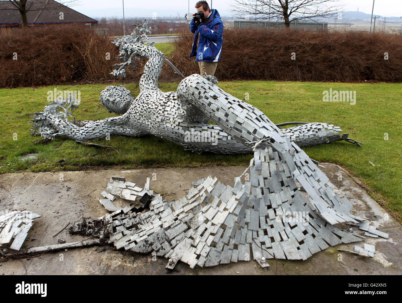 A man takes a picture of a giant sculpture created by artist Andy Scott ...