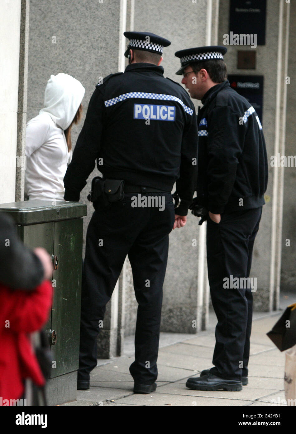 Police officers talk to an unidentified youth in the city centre of ...