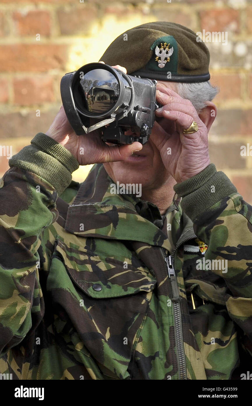 The Prince of Wales looks through a rifle scope as he meets soldiers ...