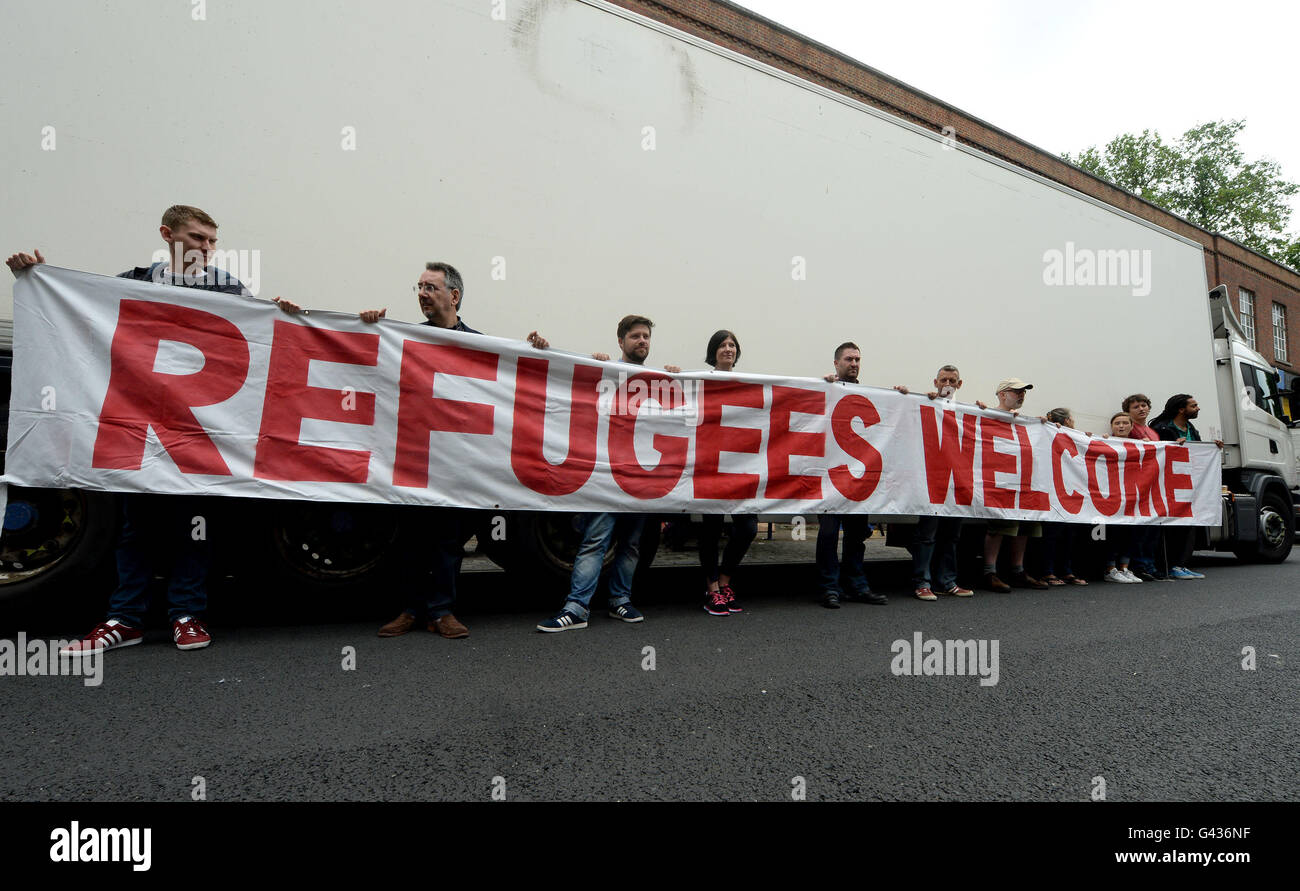 Volunteers from Convoy To Calais hold a banner beside their aid lorry ...
