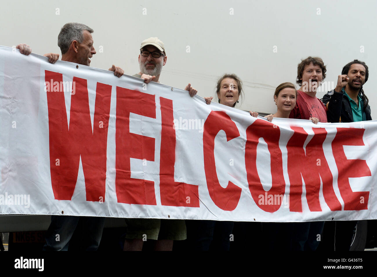 Volunteers from Convoy To Calais hold a banner beside their aid lorry ...