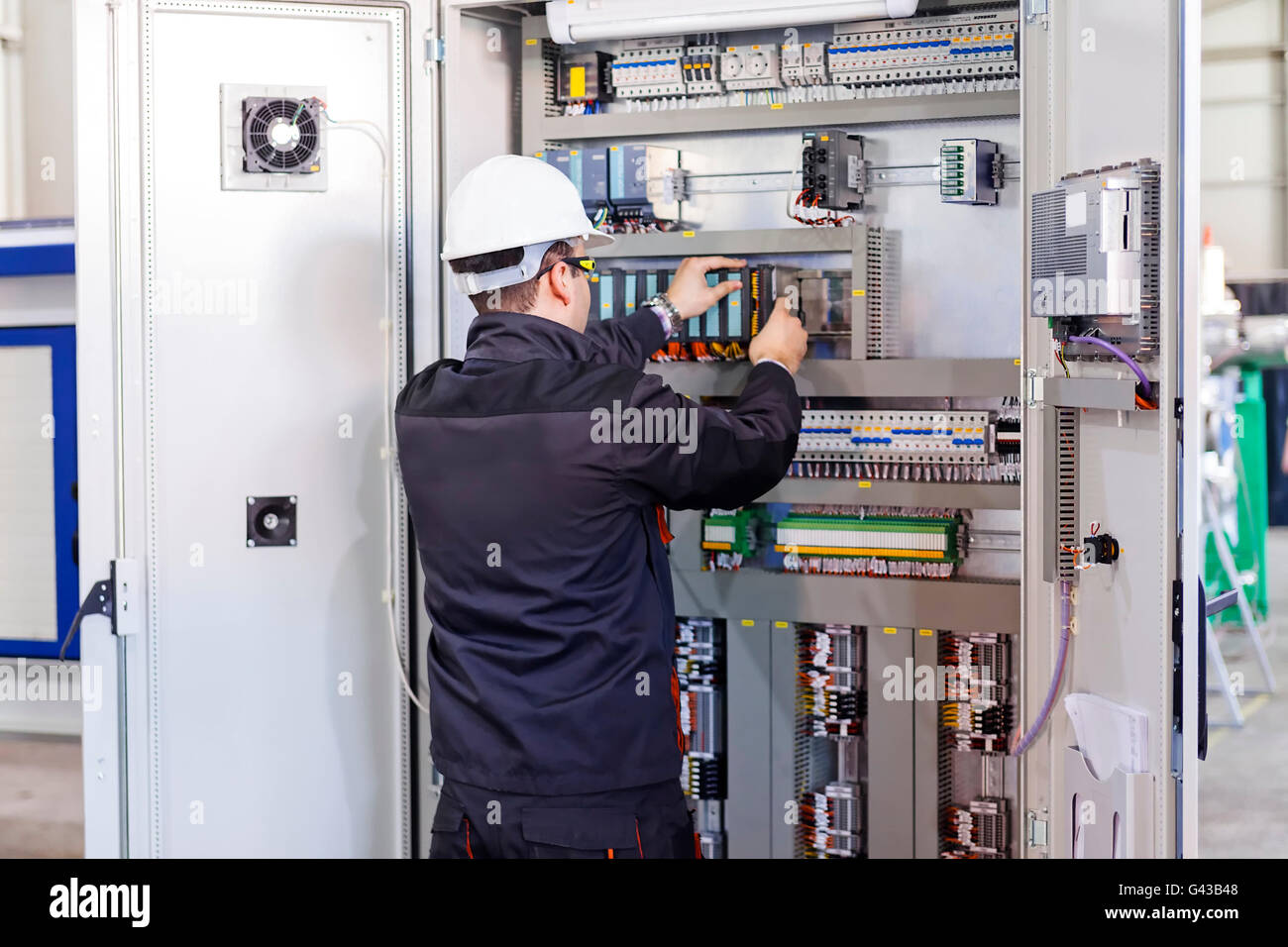 Man worker checking advanced industrial control panel; note shallow ...