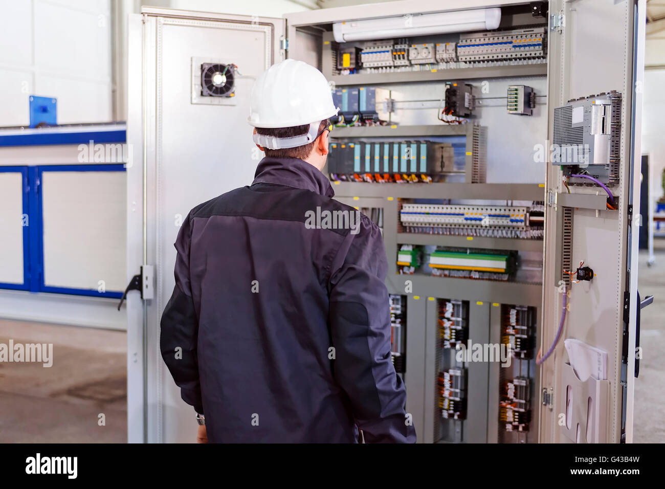 Man worker checking advanced industrial control panel; note shallow ...
