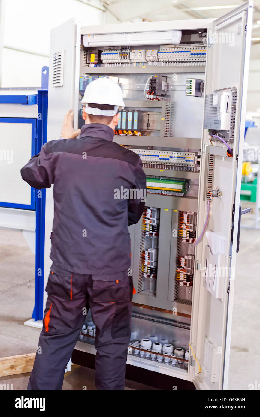Man worker checking advanced industrial control panel; blurred ...