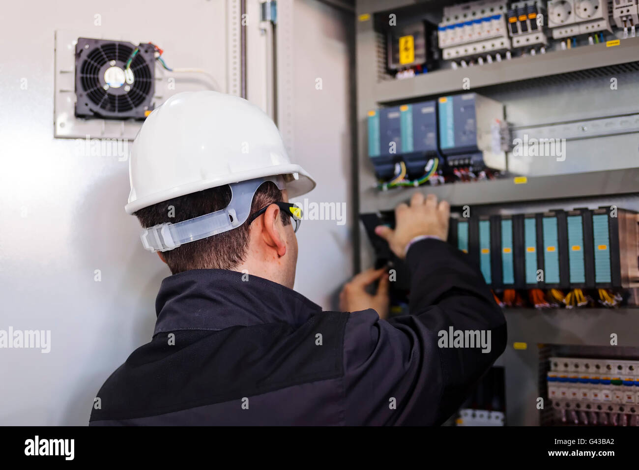Closeup man worker checking advanced industrial control panel; note ...