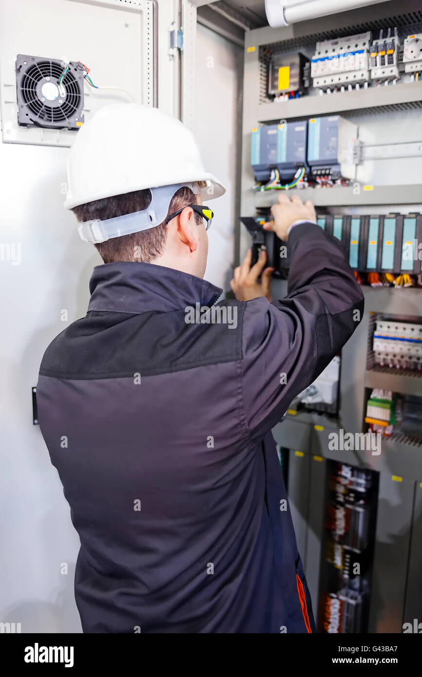 Closeup man worker checking advanced industrial control panel; note ...