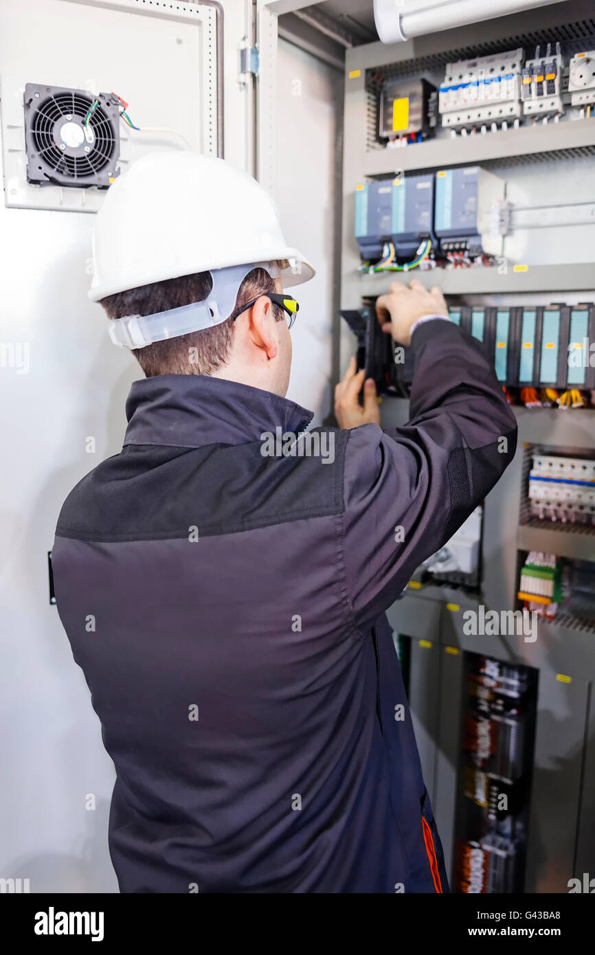 Closeup man worker checking advanced industrial control panel; note ...