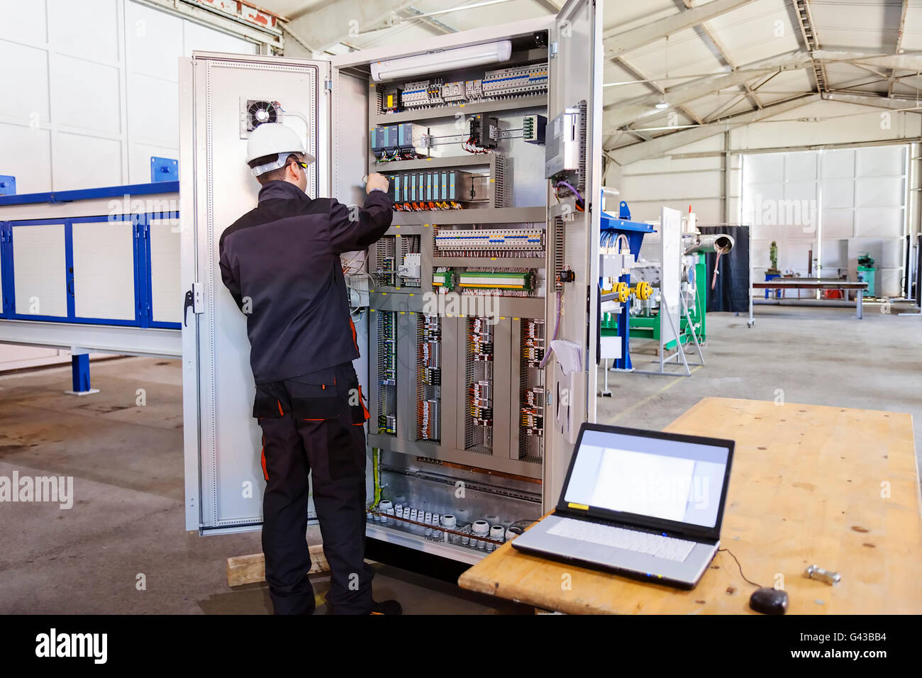 Man worker checking advanced industrial control panel in the production ...