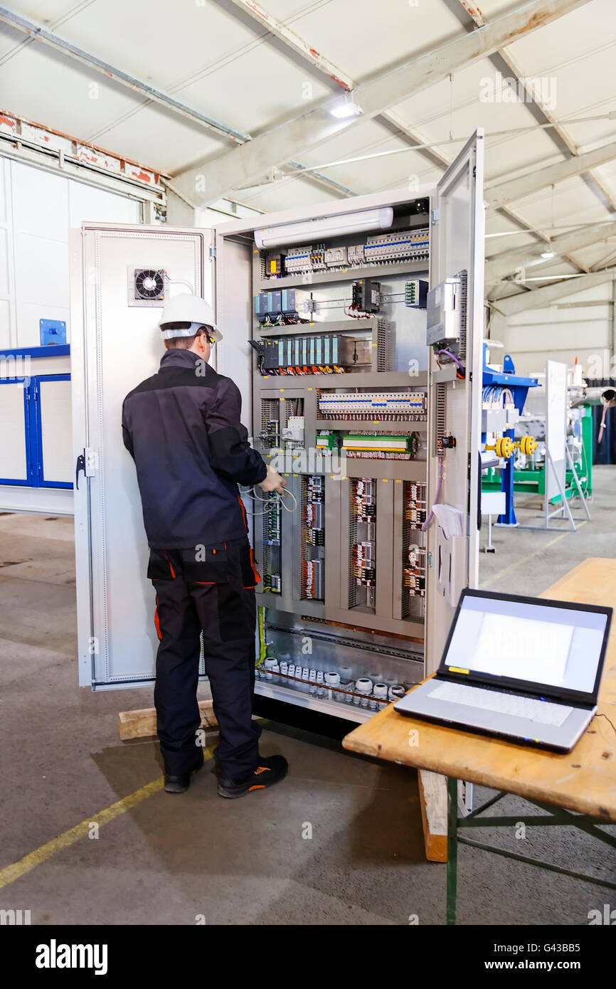 Man worker checking advanced industrial control panel in the production ...