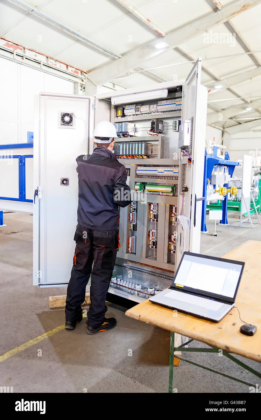 Man worker checking advanced industrial control panel in the production ...